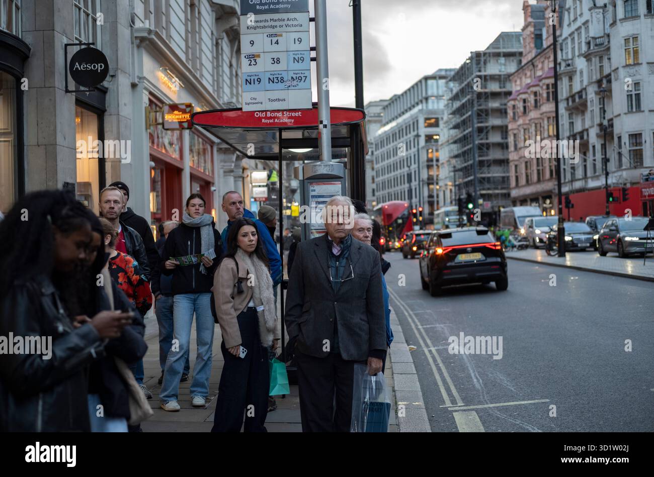 London commuters queuing at a bus shelter waiting to travel home during ...