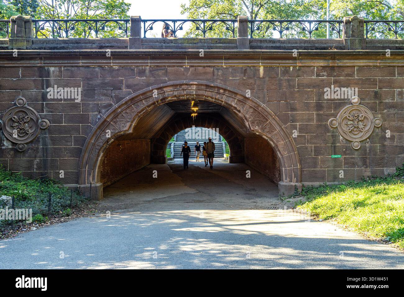 People walk through Trefoil Arch in Central Park, Manhattan, New York ...