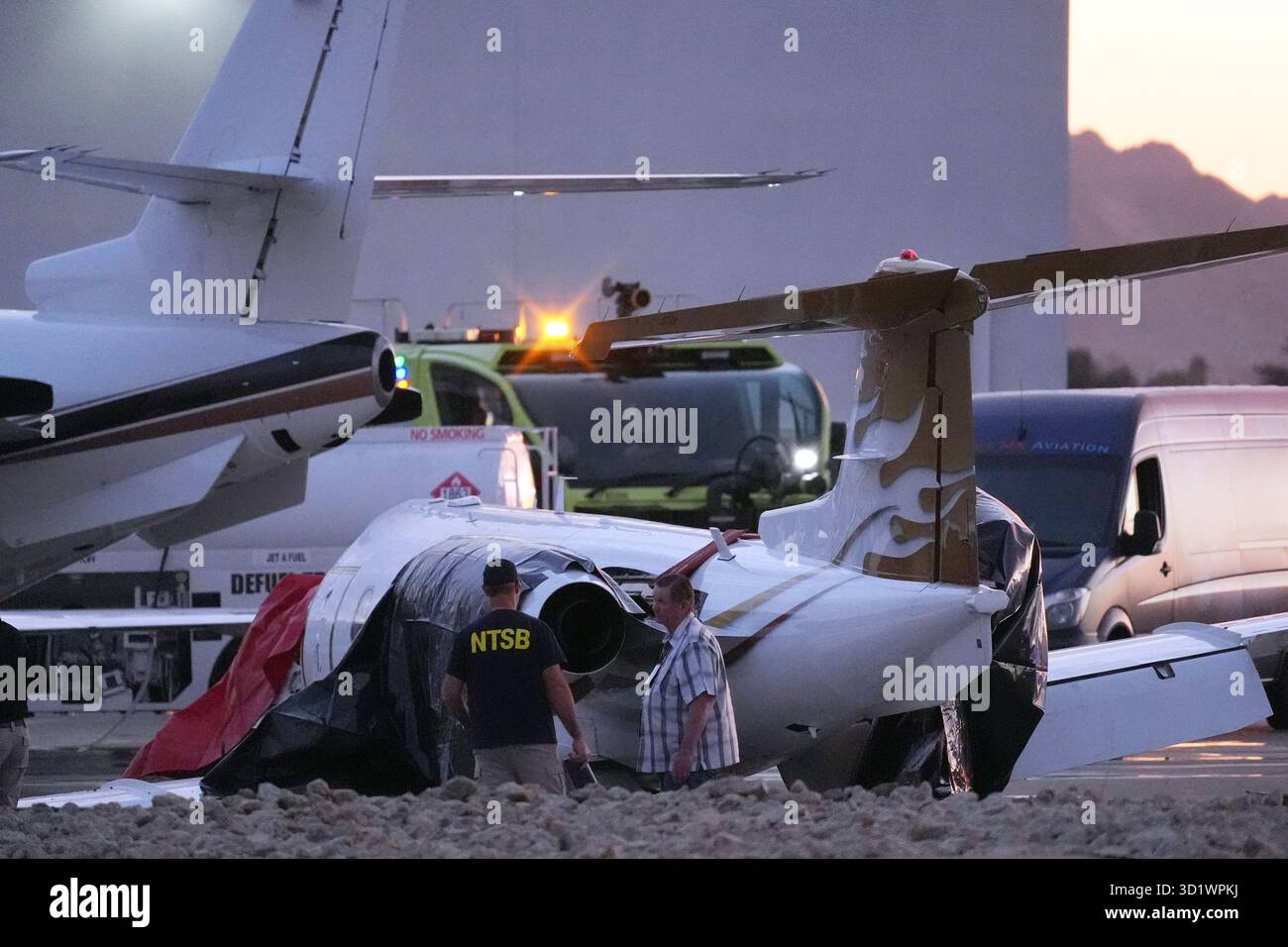FILE - Investigators look at a crashed Learjet at Scottsdale Airport ...