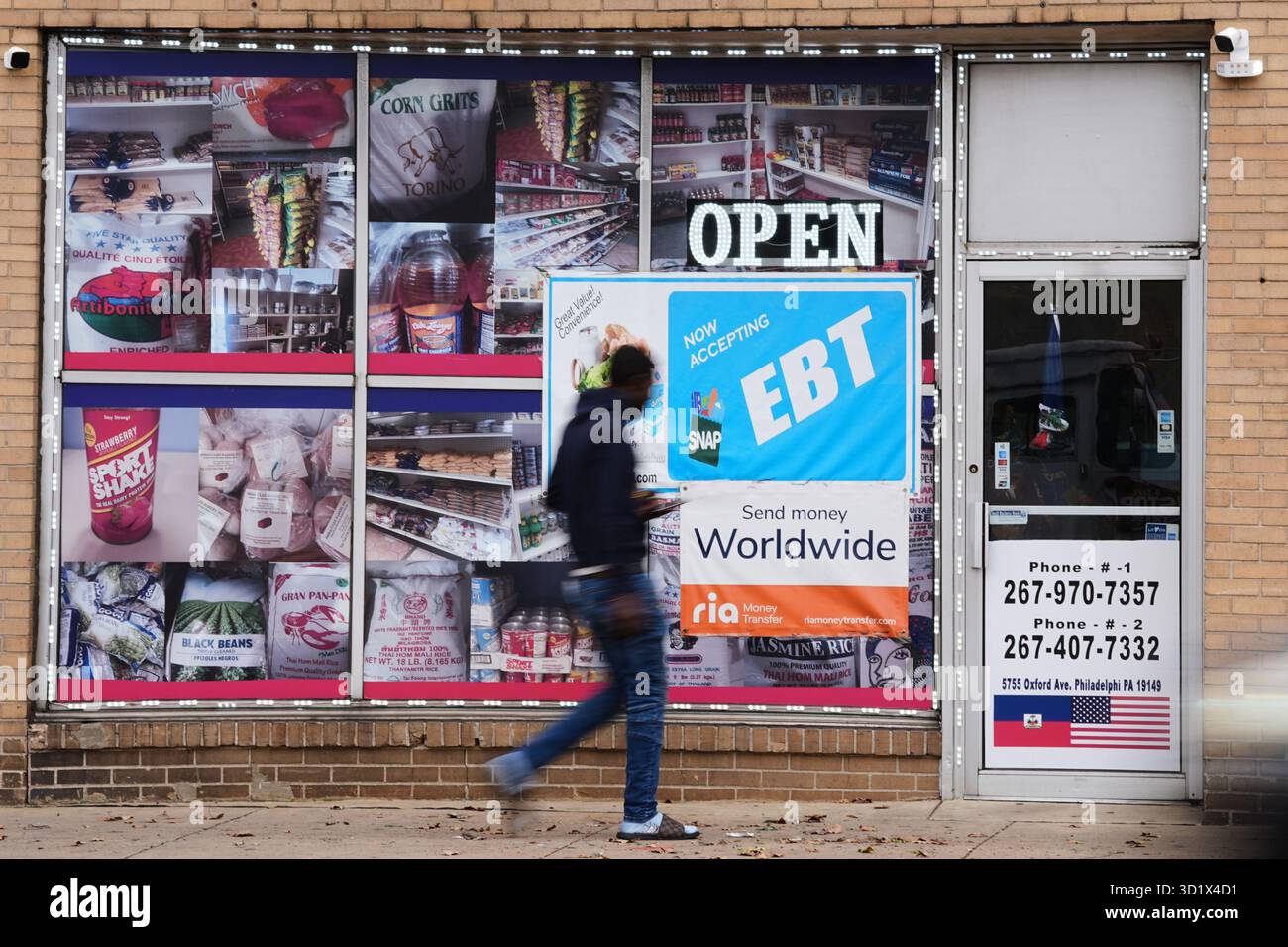 A customer walks past an EBT payment sign posted on the front window of ...