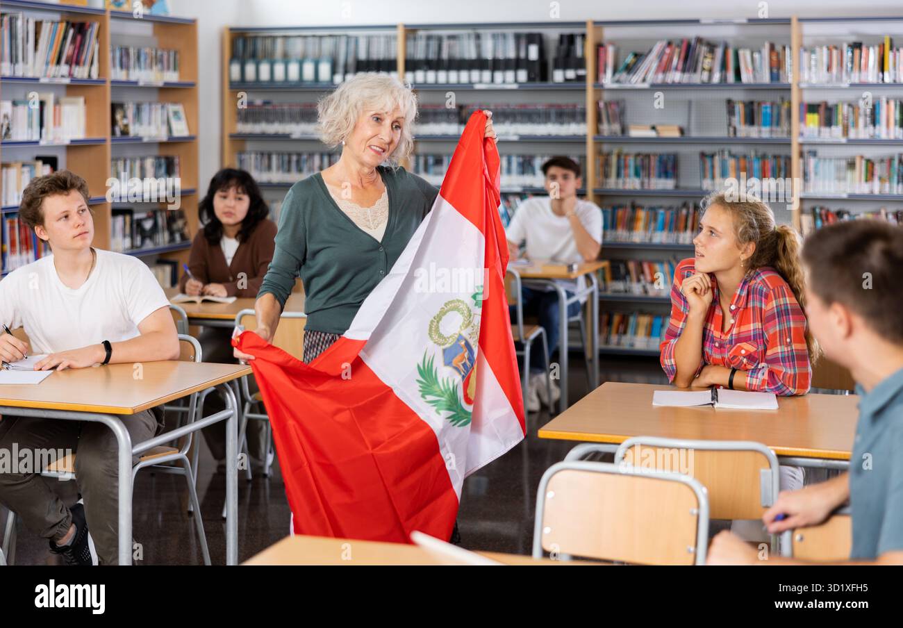 Pupils sitting in class and listening carefully to female teacher ...