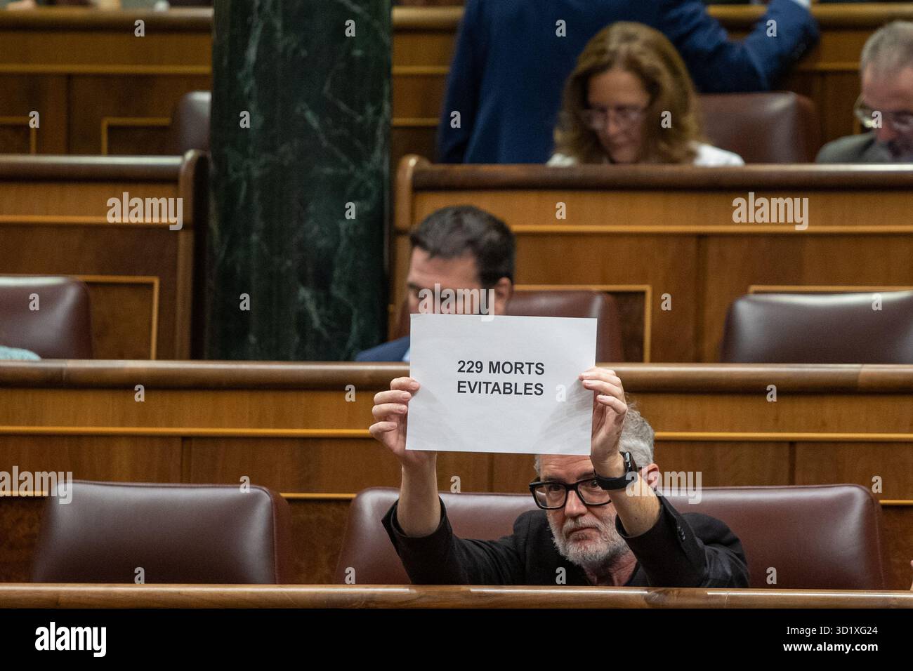 A member of Parliament holds up a sign against the People's Party (PP ...