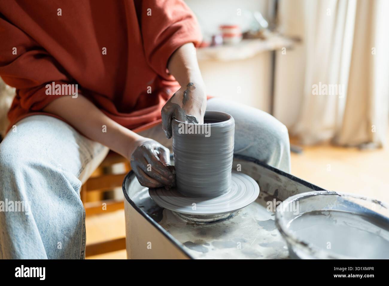 Hands of craftswoman ceramist working sitting in cozy workshop using ...
