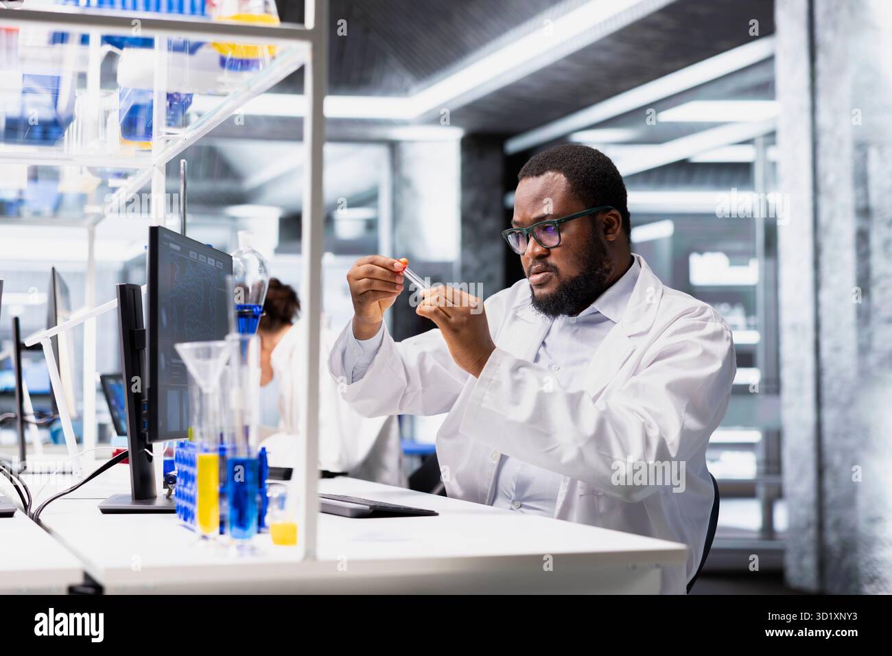Research facility expert using colorful chemical solutions in glassware ...
