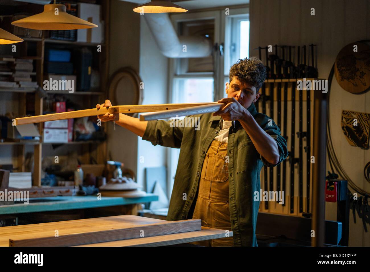 Craftsman inspects table legs and base, ensuring even surfaces and ...