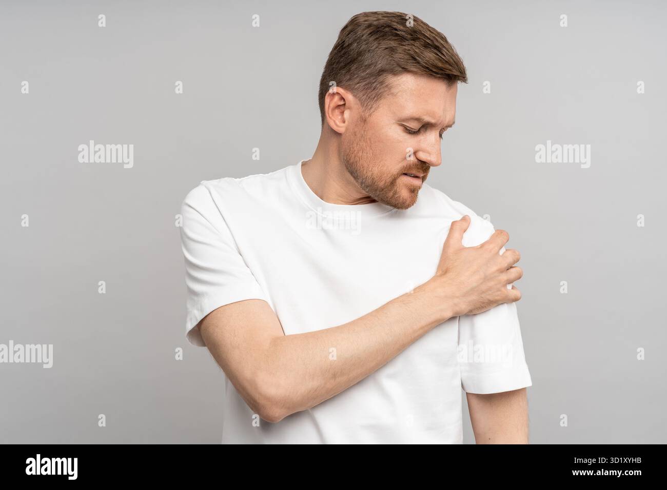 Man touching hand shoulder feeling pain isolated on gray background ...
