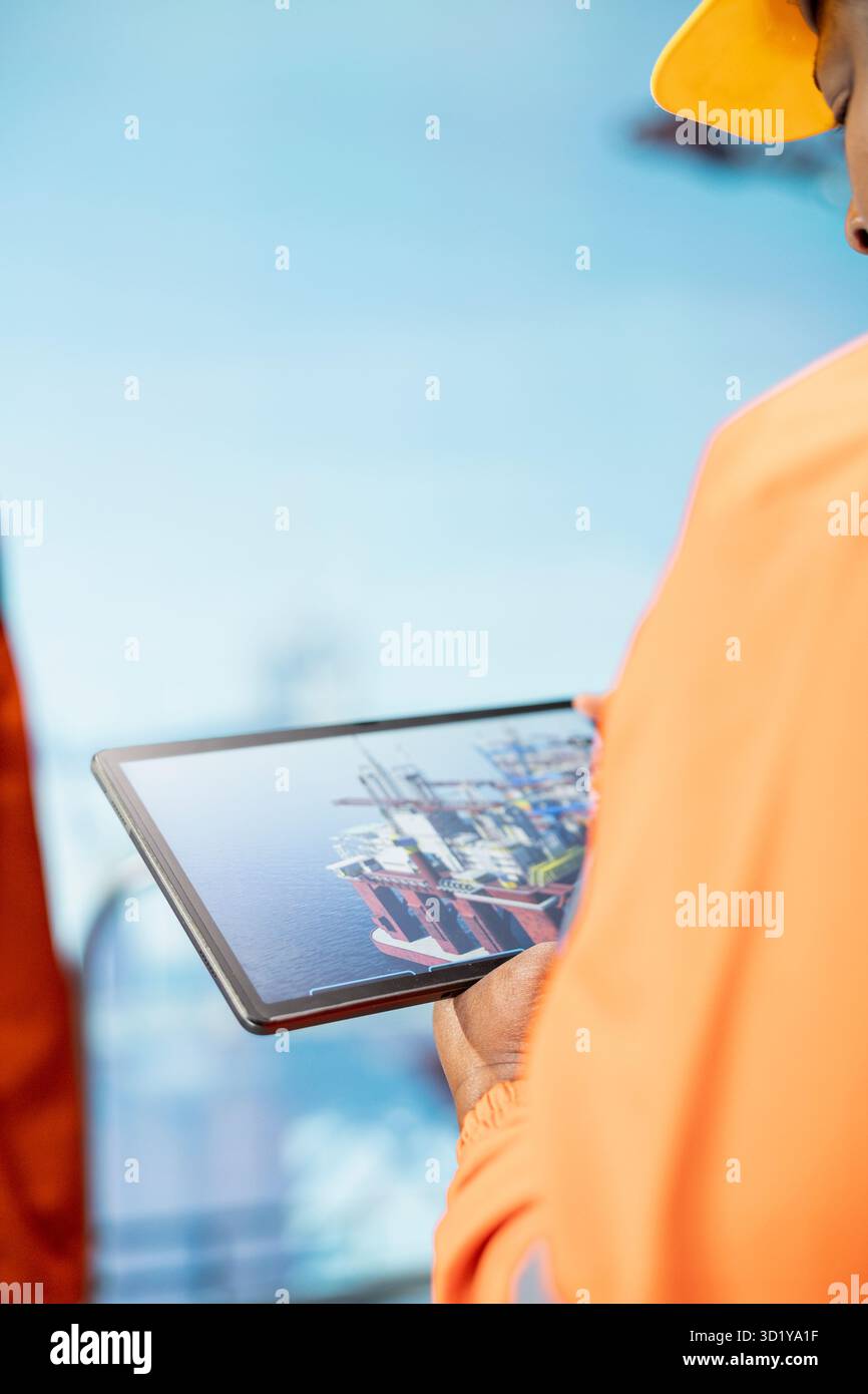 Close up of drilling rig expert using tablet app dashboard for anomaly ...