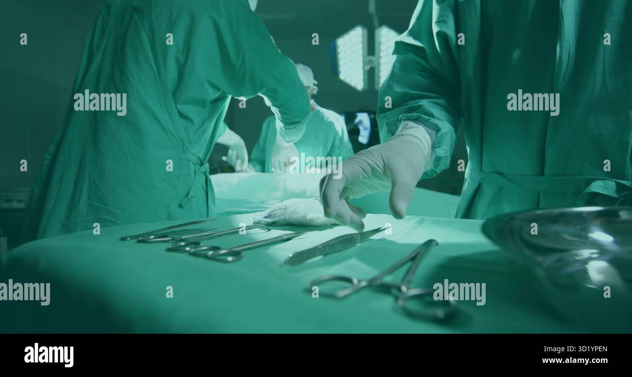 Reaching gloved surgeon's hand selecting scalpel on draped tray under ...