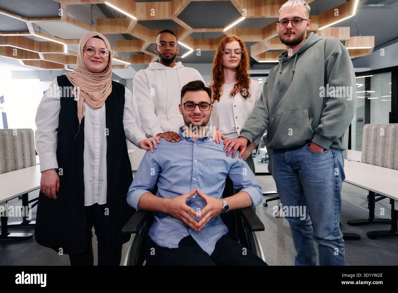 Young businessmen in a modern office extend a handshake to their ...