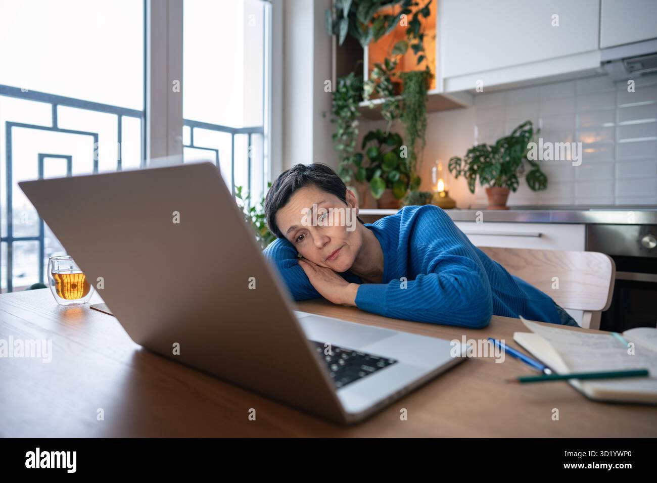 Indifferent mature woman leaning on desk, stare at laptop. Burnout ...