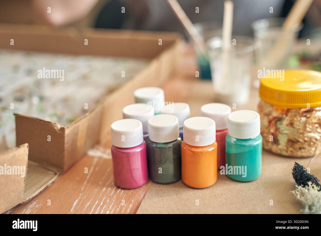 Assorted paint jars and craft materials on table for creative art ...