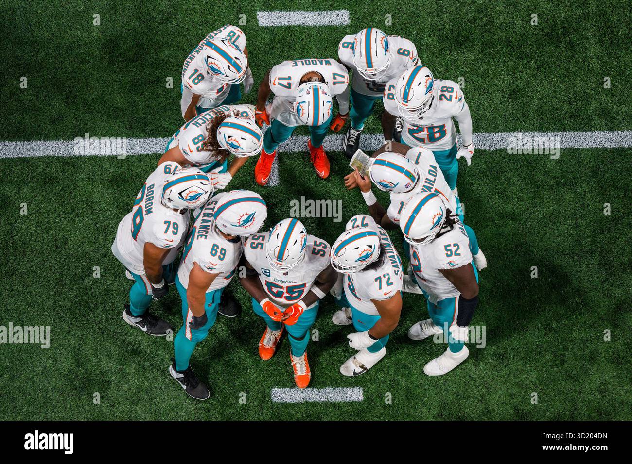The Miami Dolphins offense huddles during the first half of an NFL ...