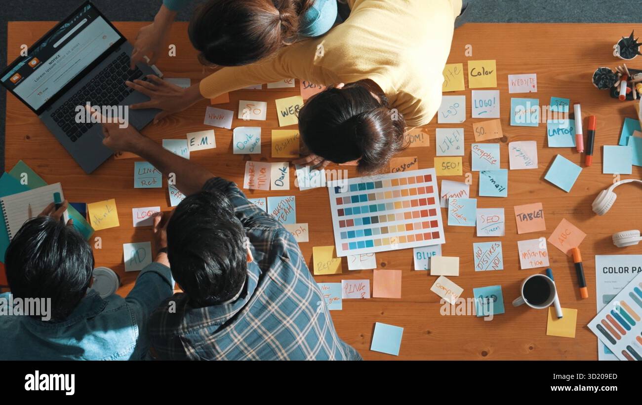 Top down view of business team with casual outfit looking laptop screen ...