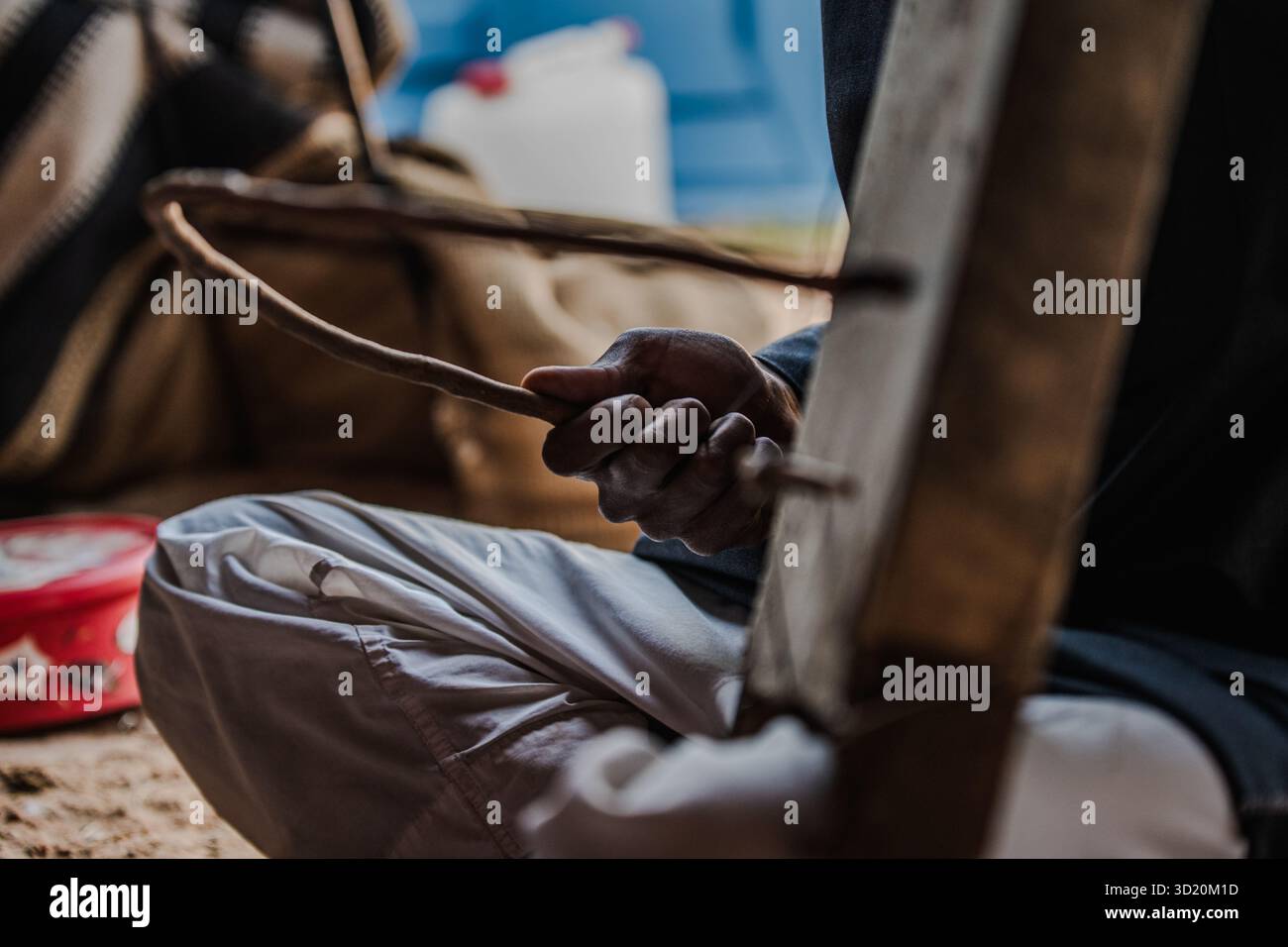 Bedouin musician’s hands holding a handmade rababa instrument during a ...