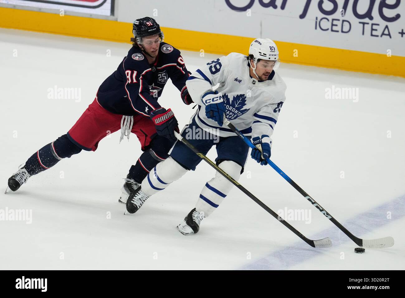 Columbus Blue Jackets center Kent Johnson (91) reaches for the puck ...