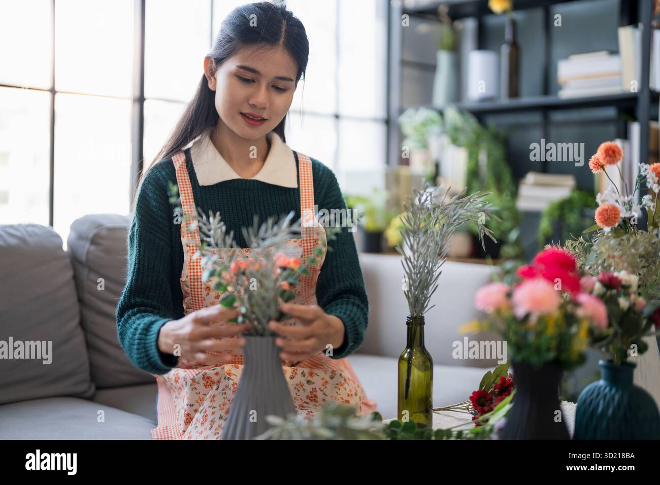 Happy asian Woman arranging flowers caring for home greenery Stock ...