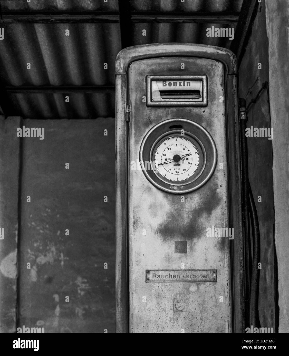 A vintage gas pump with a pressure gauge, showing signs of wear and age ...
