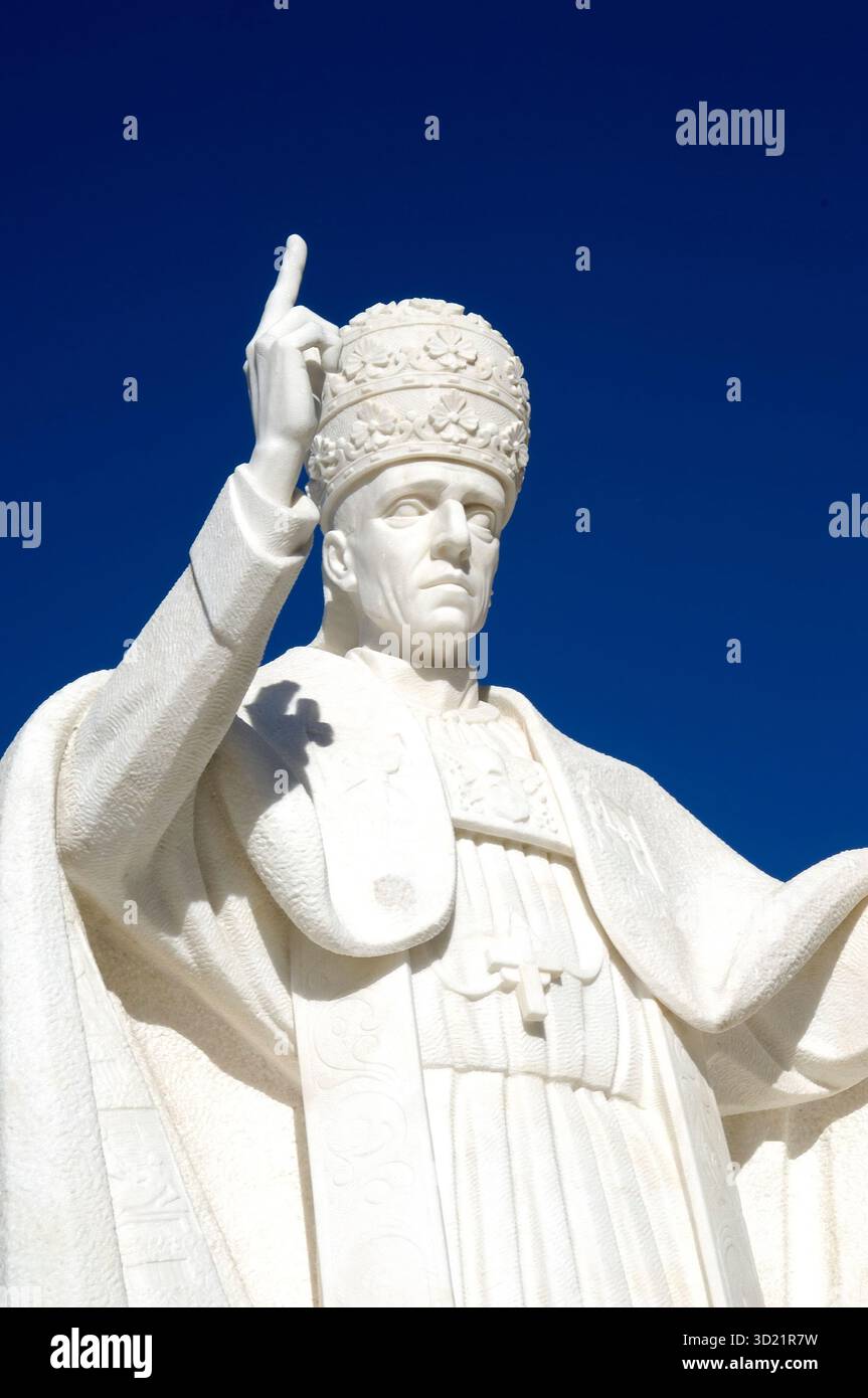 White marble statue of Pope John Paul II raising his right index finger ...