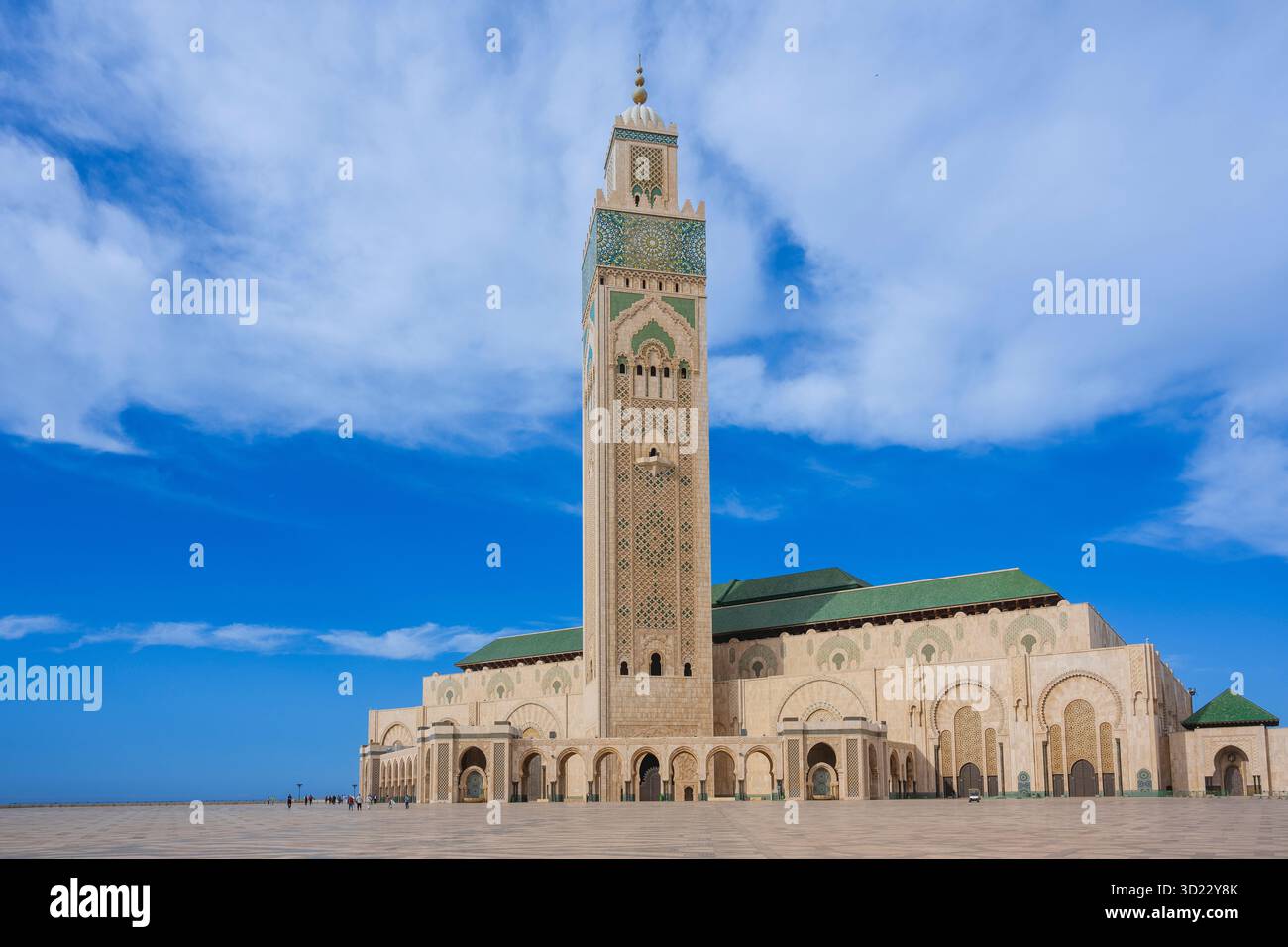 Majestic mosque with tall minaret under a clear blue sky and scattered ...