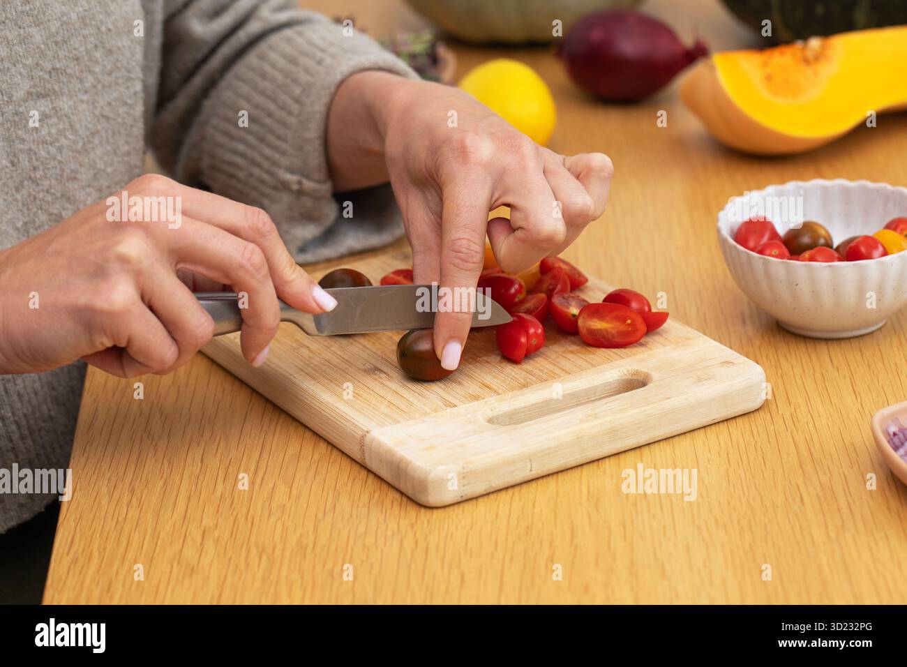 Slicing cherry tomatoes preparing ingredients hi-res stock photography ...