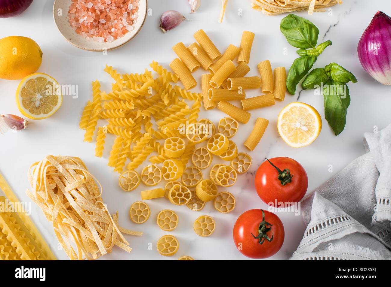 Homemade dry pasta with various ingredients on marble table Stock Photo ...