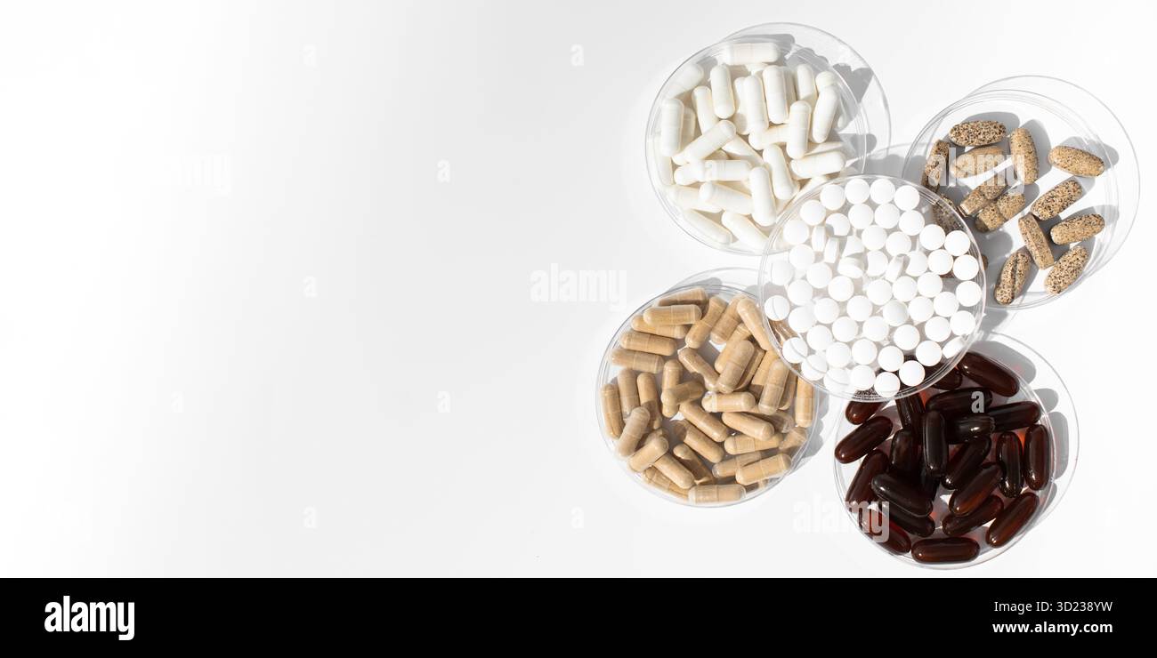 Various vitamins and dietary supplements in small medical plates ...