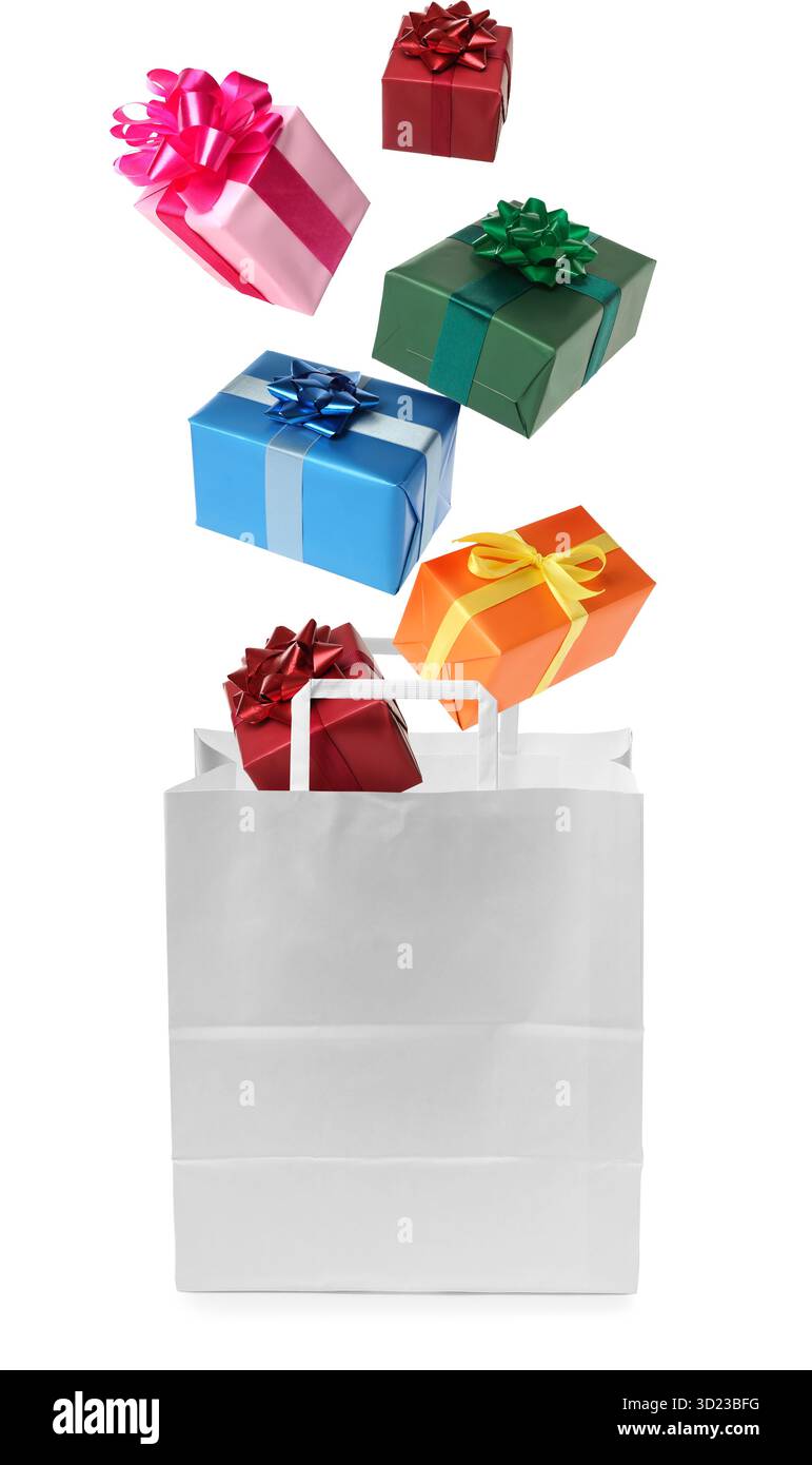 Many gift boxes falling into paper bag on white background Stock Photo ...