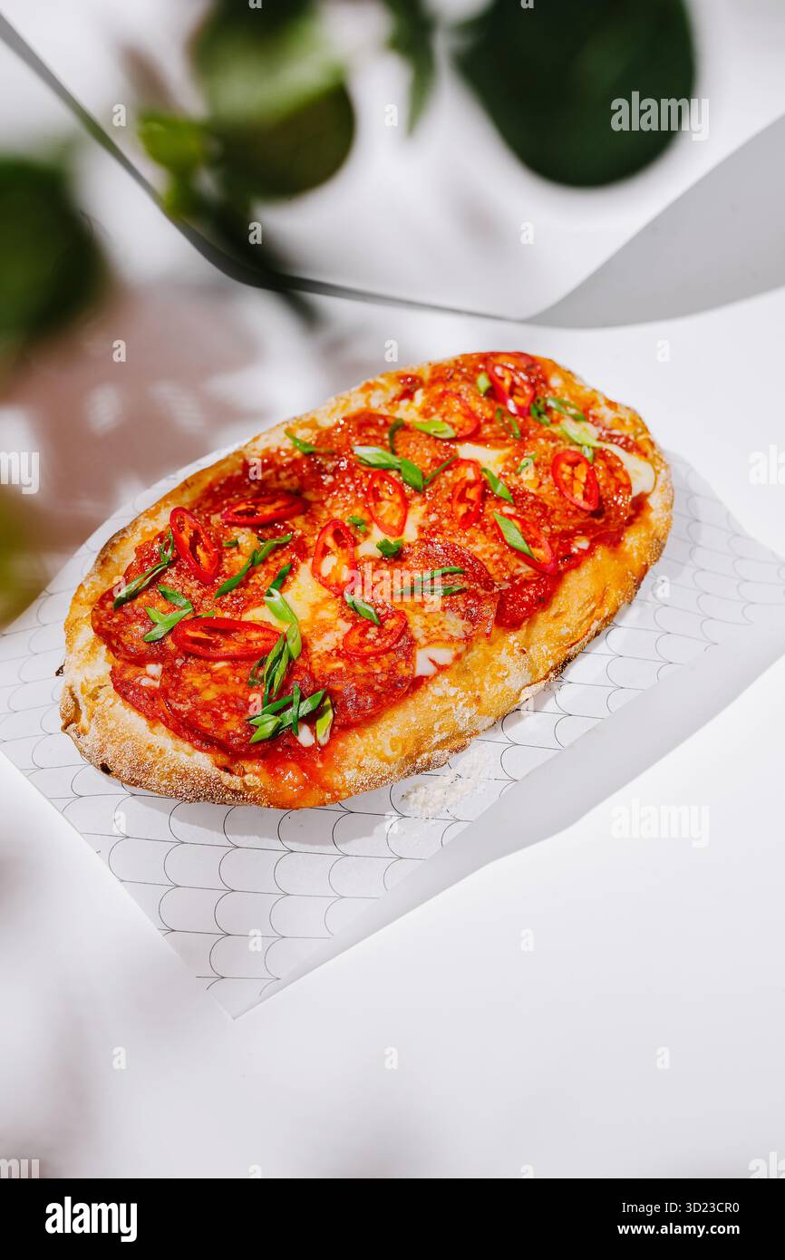 Delicious flatbread topped with spicy pepperoni and herbs on a serving ...