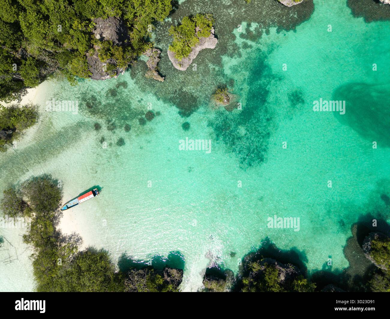 Aerial view of turquoise water, lush green islands, and a boat in a ...