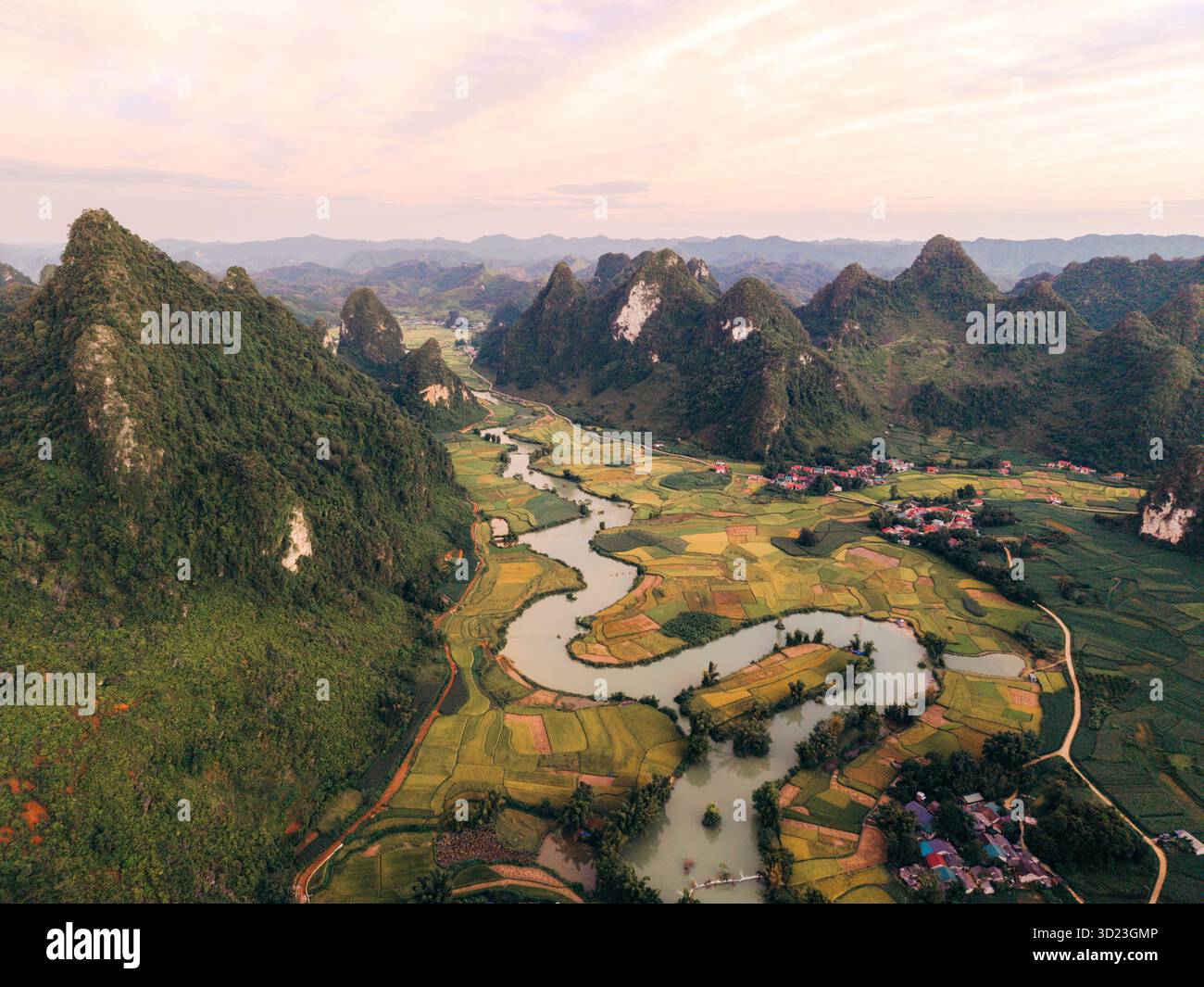 Aerial view of winding river through lush green valley surrounded by ...