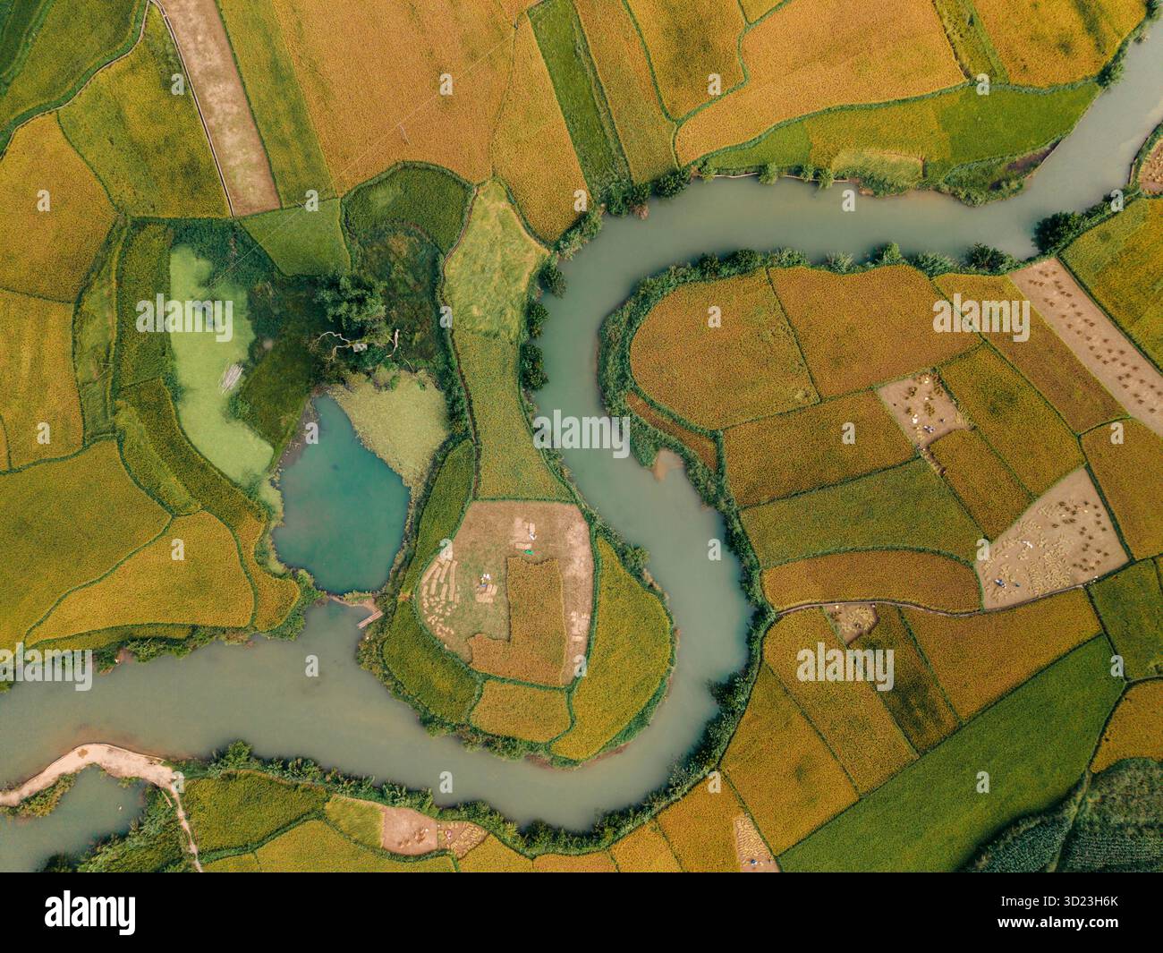 Aerial view of a winding river cutting through patchwork fields with ...
