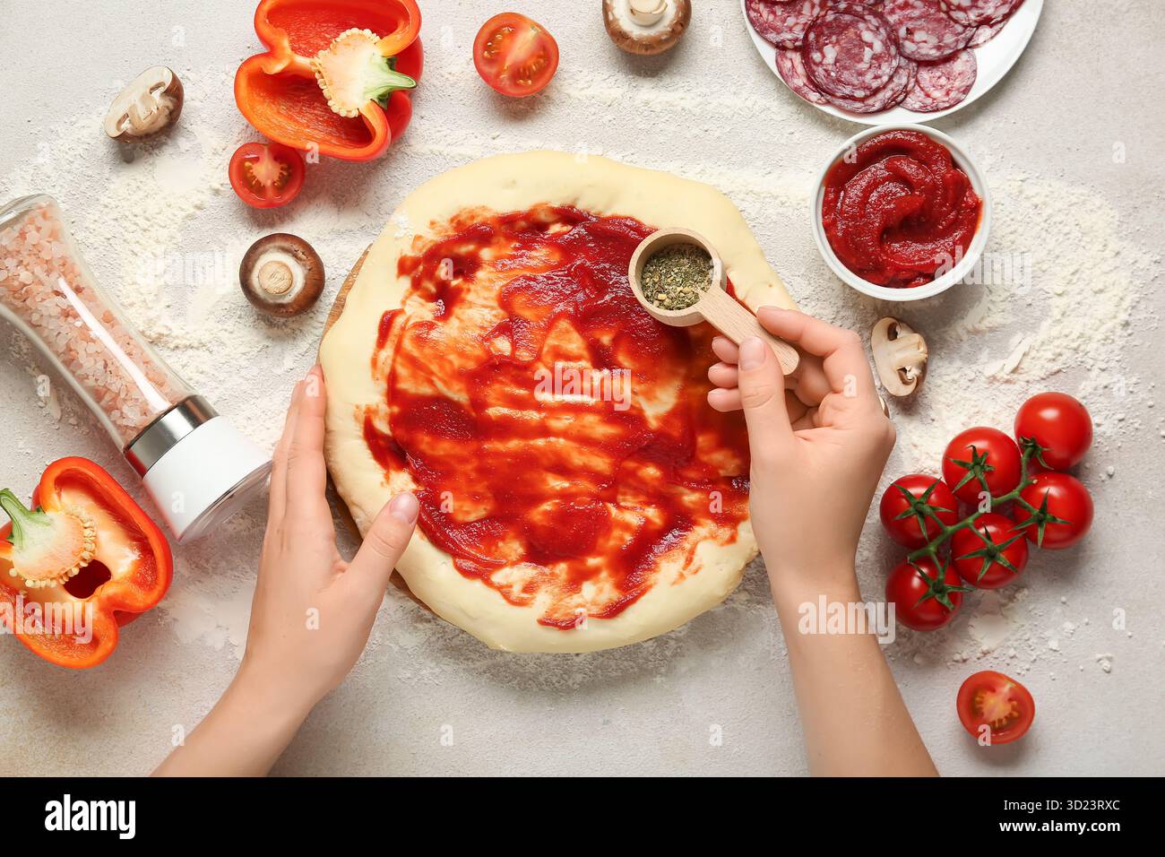 Female hands with pizza dough, tasty tomato sauce and ingredients on ...