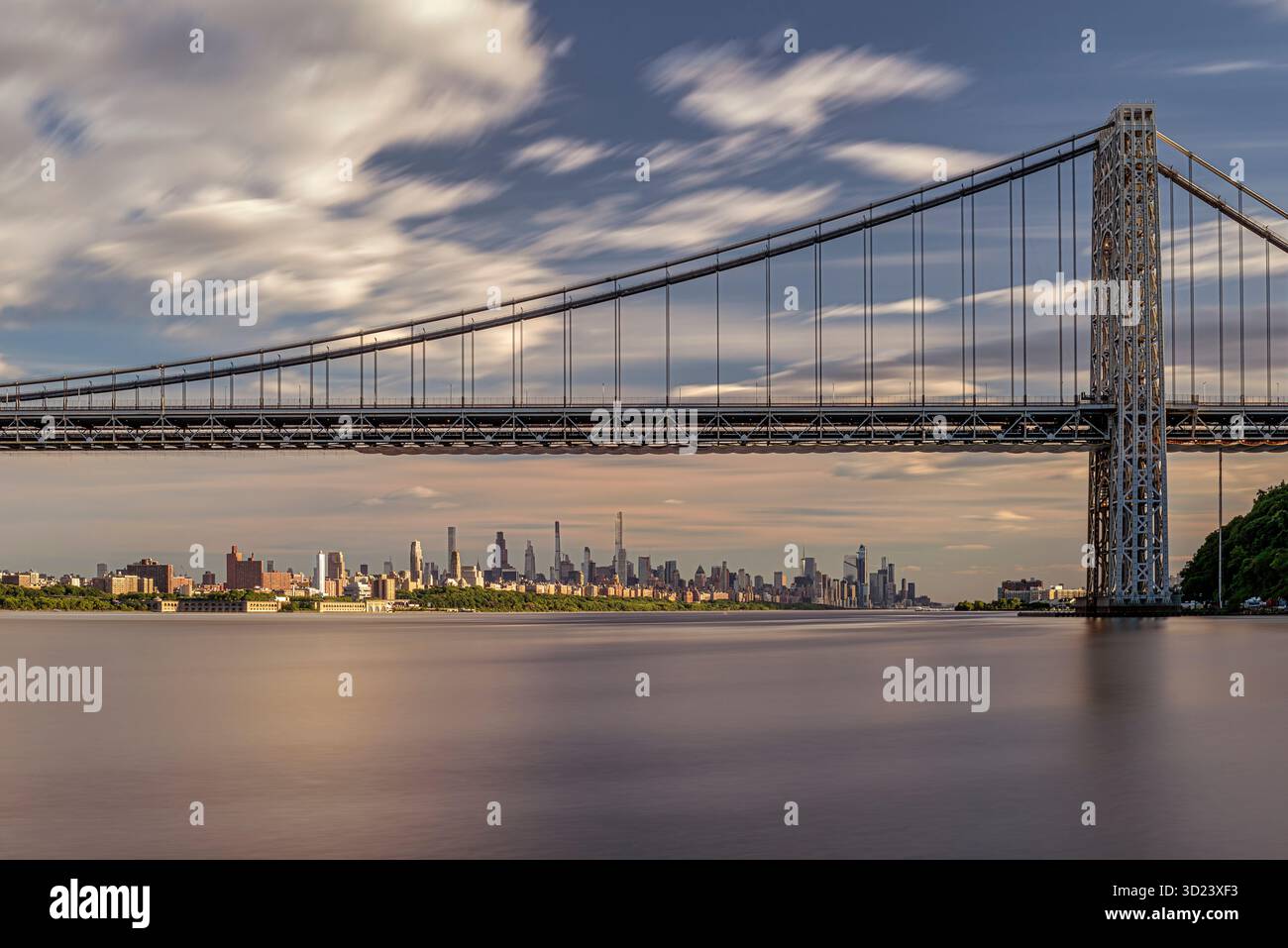 Stunning suspension bridge with city skyline under a dynamic cloud ...