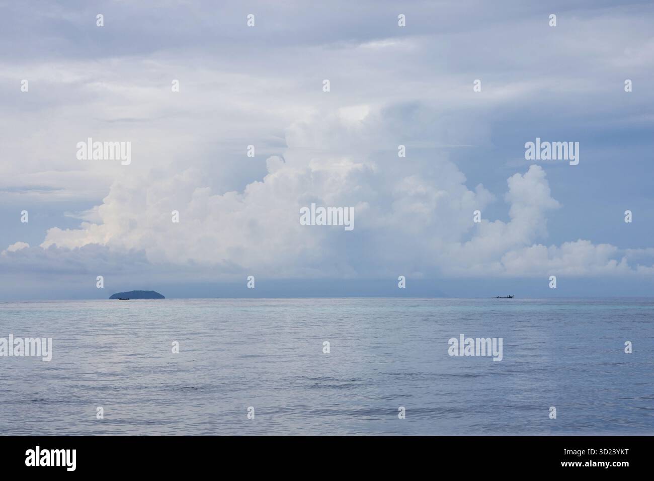Vast ocean view with distant island and boat under expansive cloudy sky ...