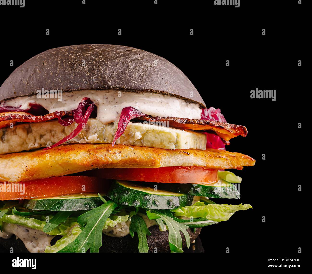 A towering black burger features layers of crispy bacon, grilled ...