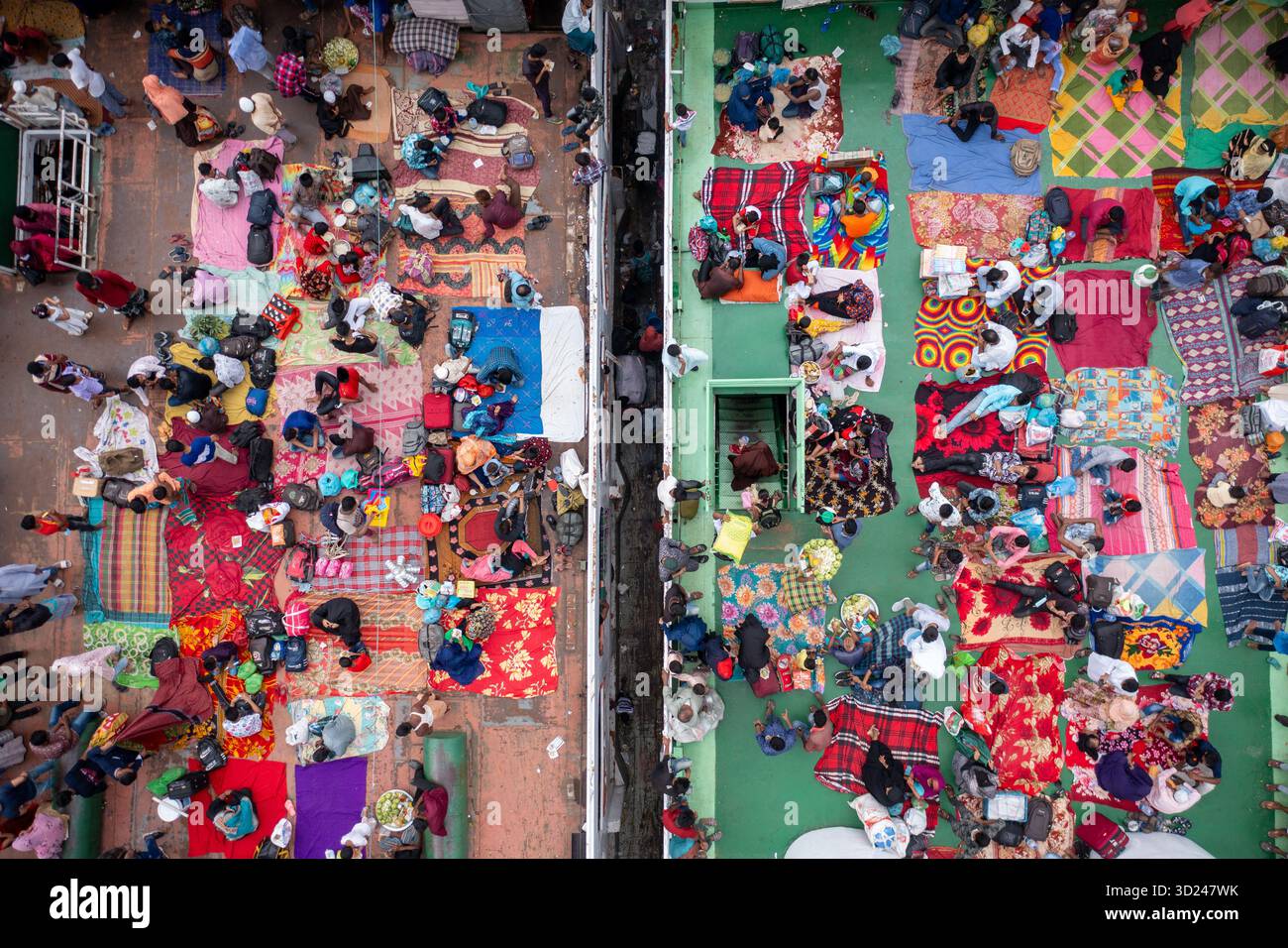 Aerial view of colorful textiles and people congregated on mats ...