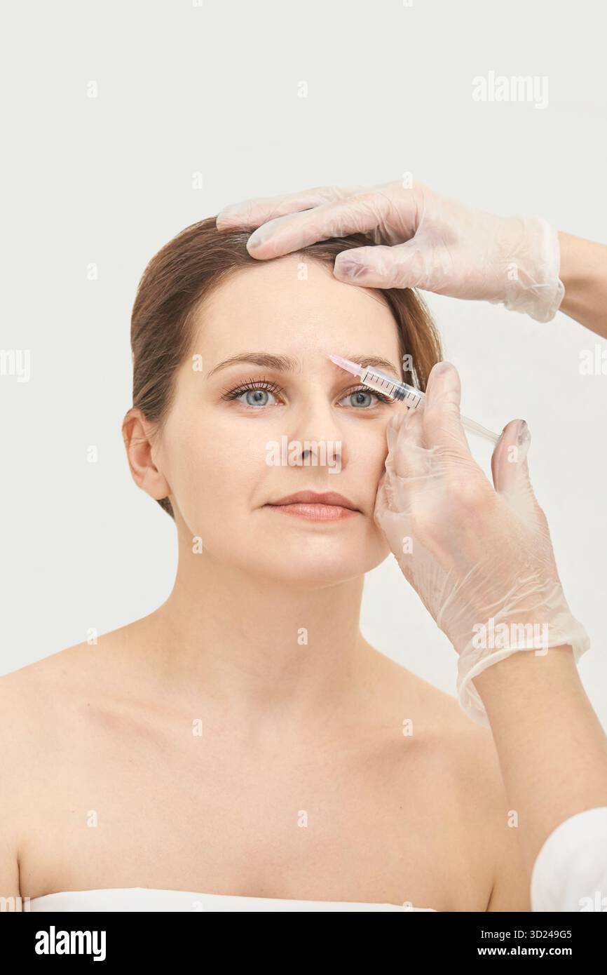 Patient receiving forehead injection from hi-res stock photography and ...