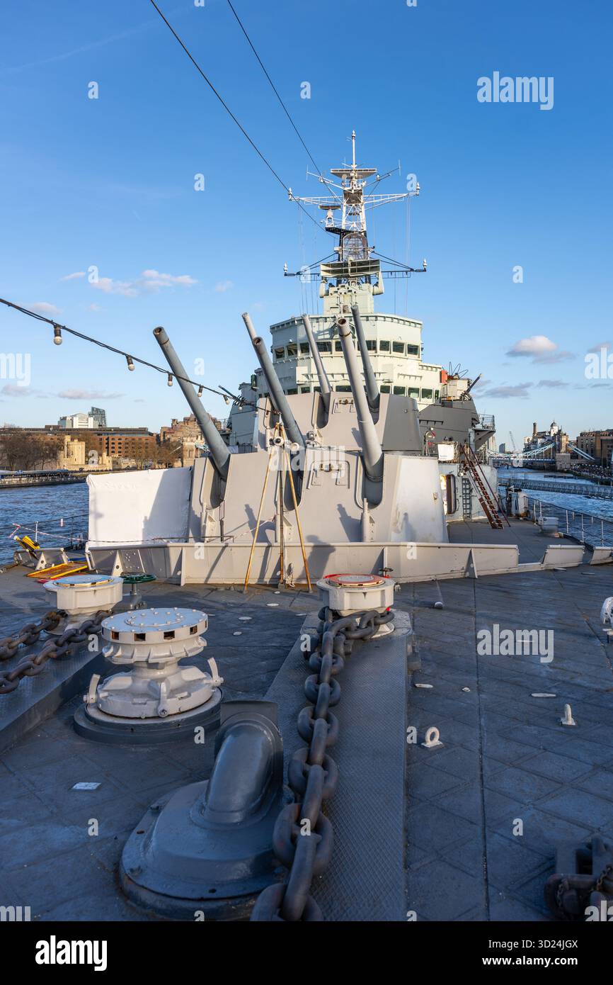 The turrets of HMS Belfast stand tall against the clear blue sky in ...