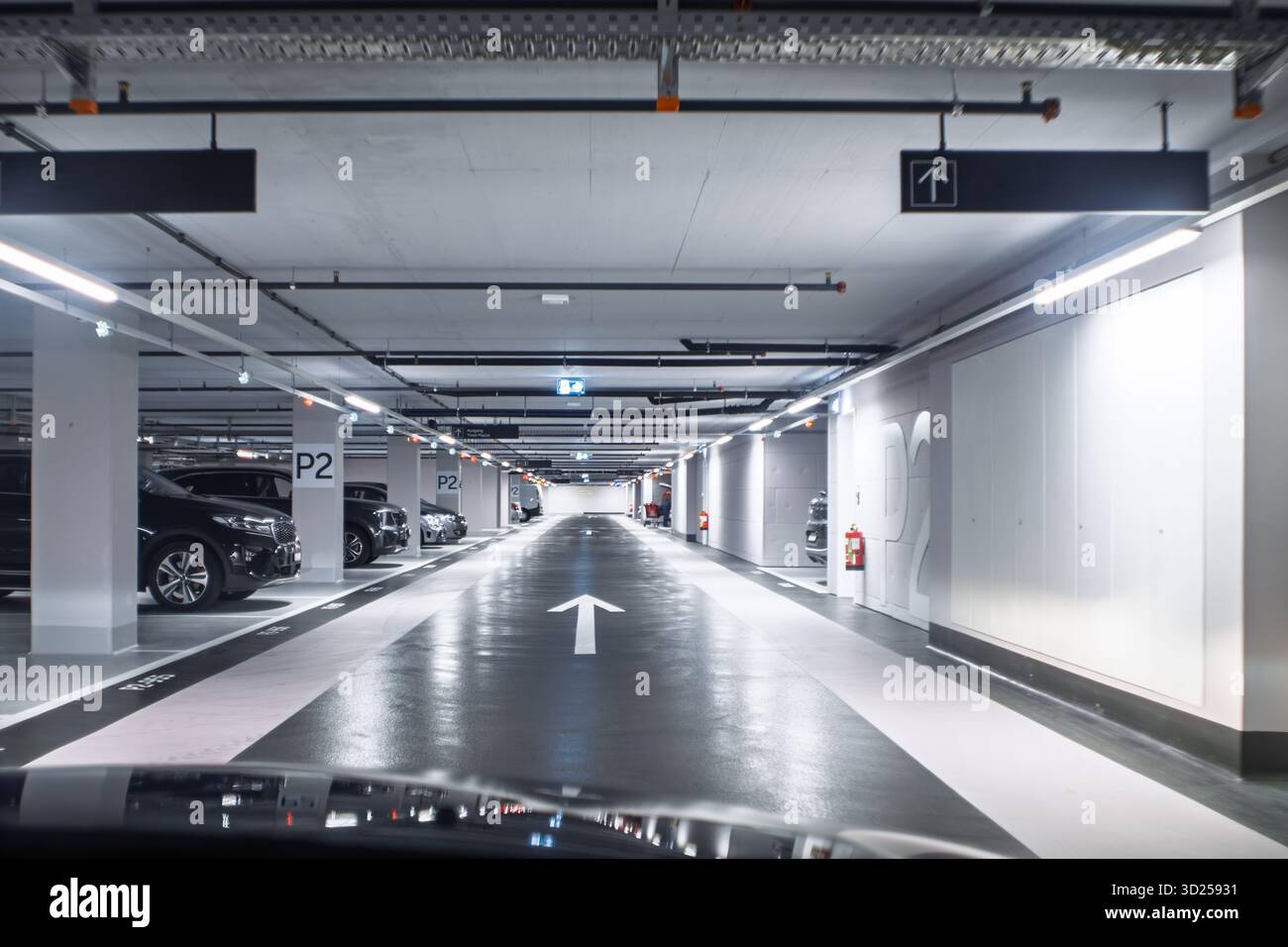 Empty long aisle in a modern underground parking garage with generic ...