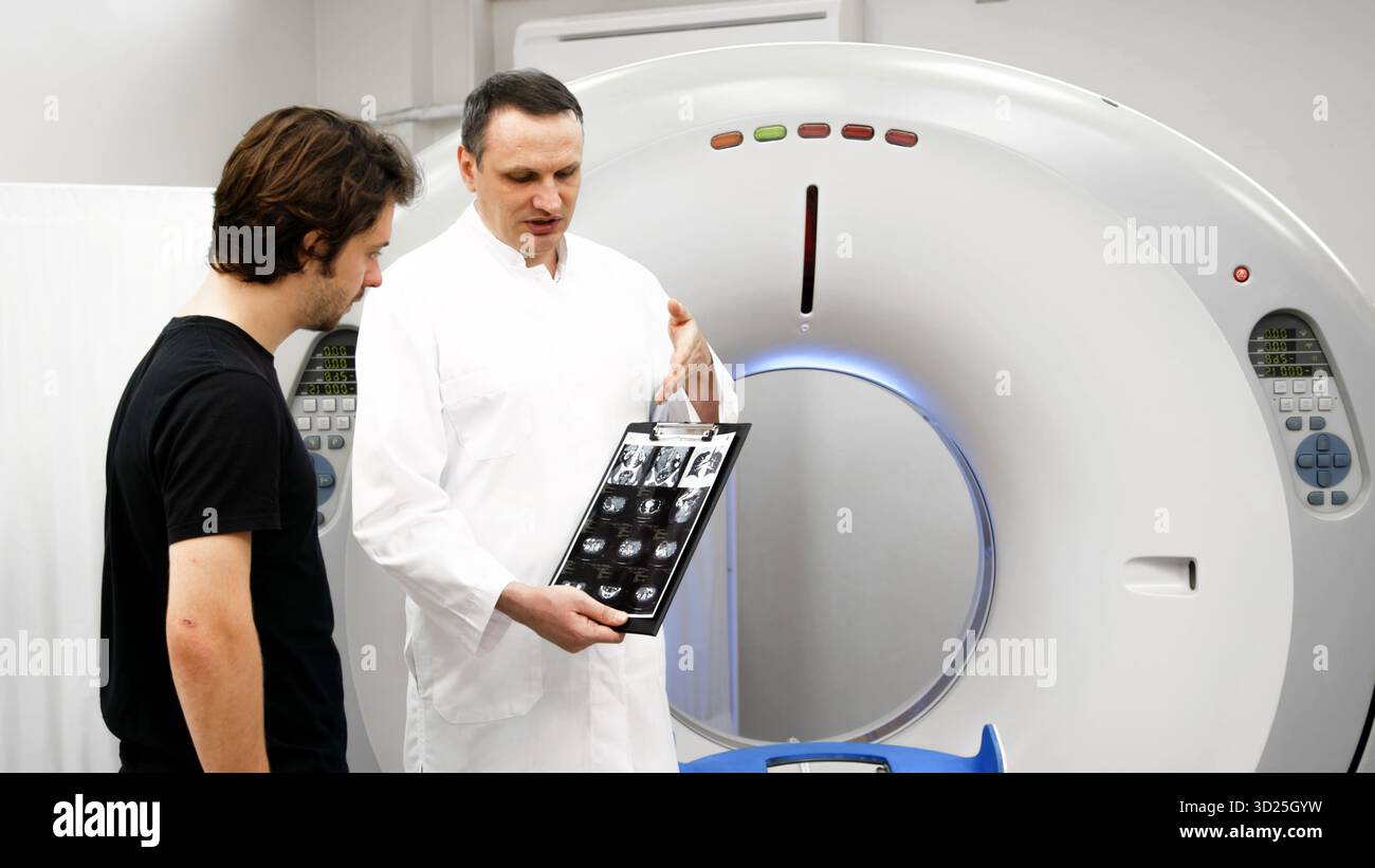 Healthcare provider discusses CT scan images with patient in clinical ...