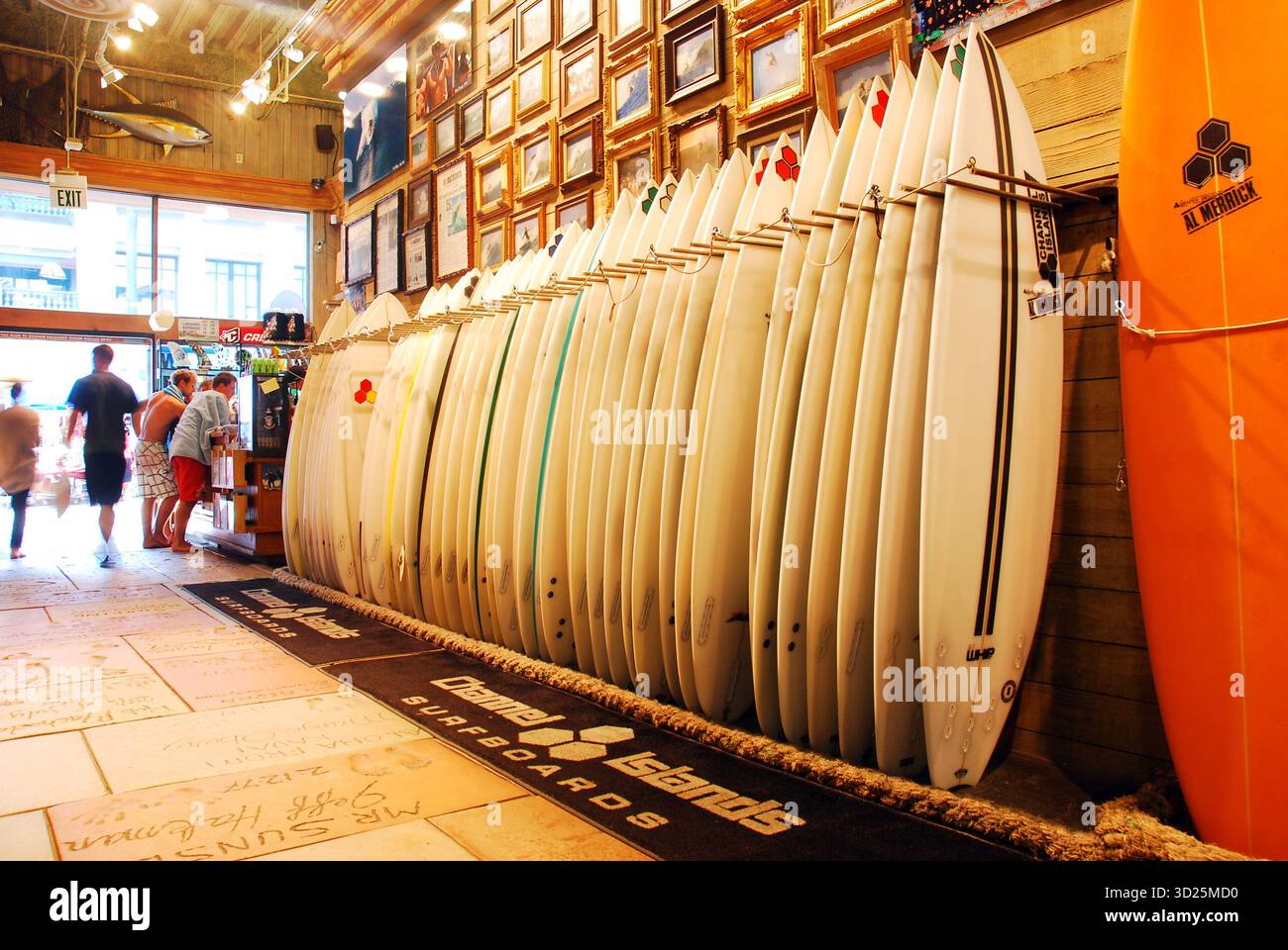 A long line of surfboards are set up inside a surf shop in downtown ...