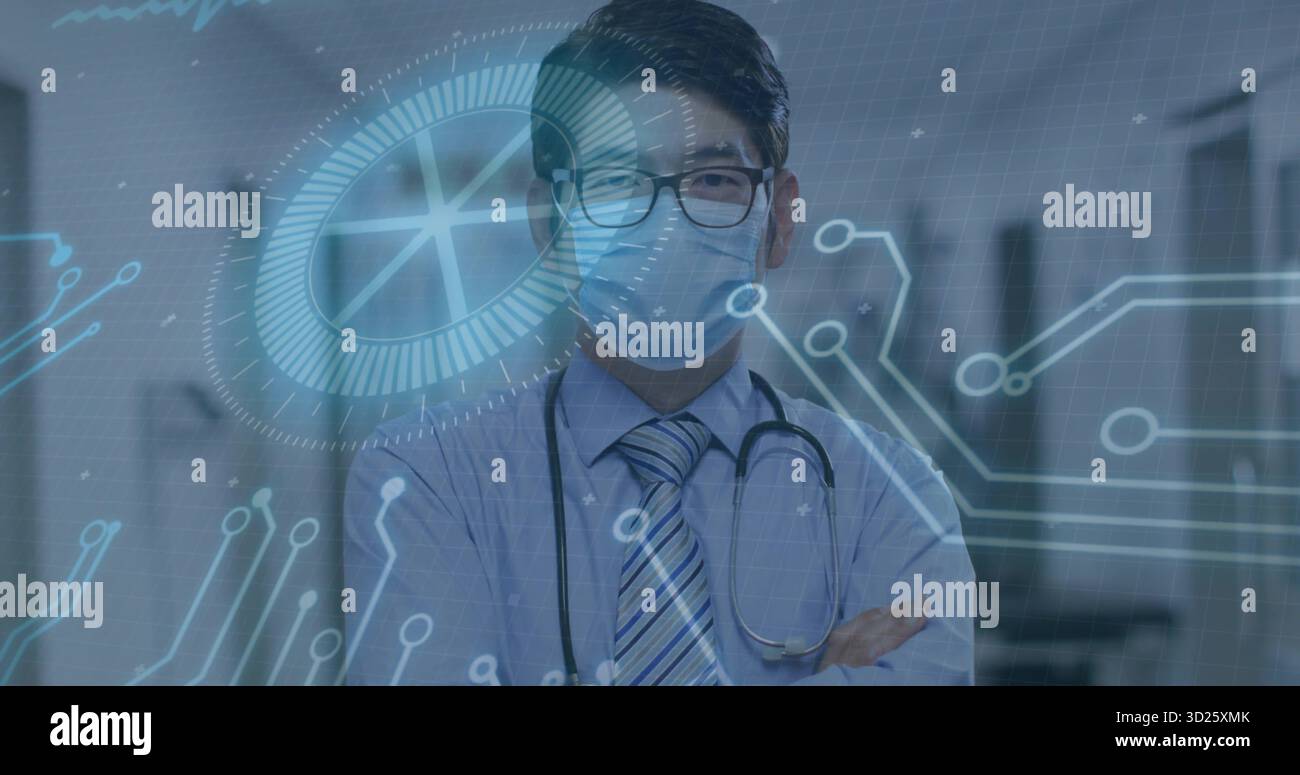 Standing doctor crossing arms in hospital corridor, with mask, specs ...