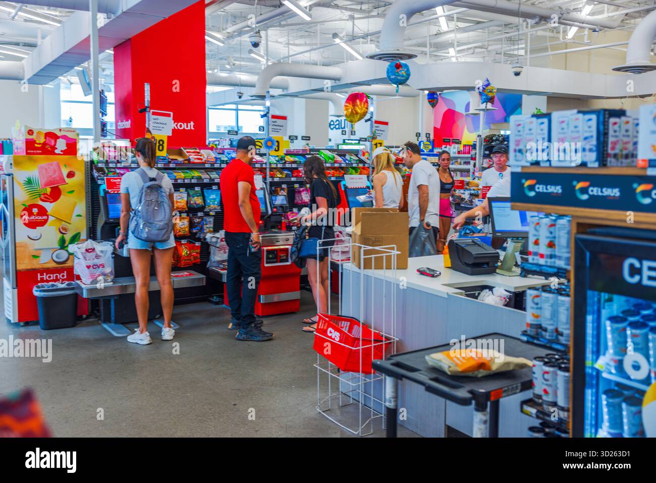 People standing in line at CVC store self checkout area with products ...