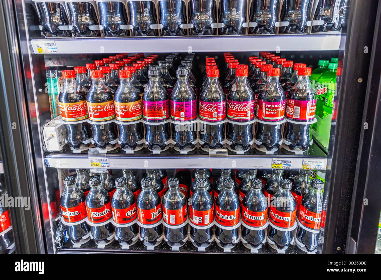 Coca Cola and Cherry Coke bottles neatly arranged on refrigerator ...