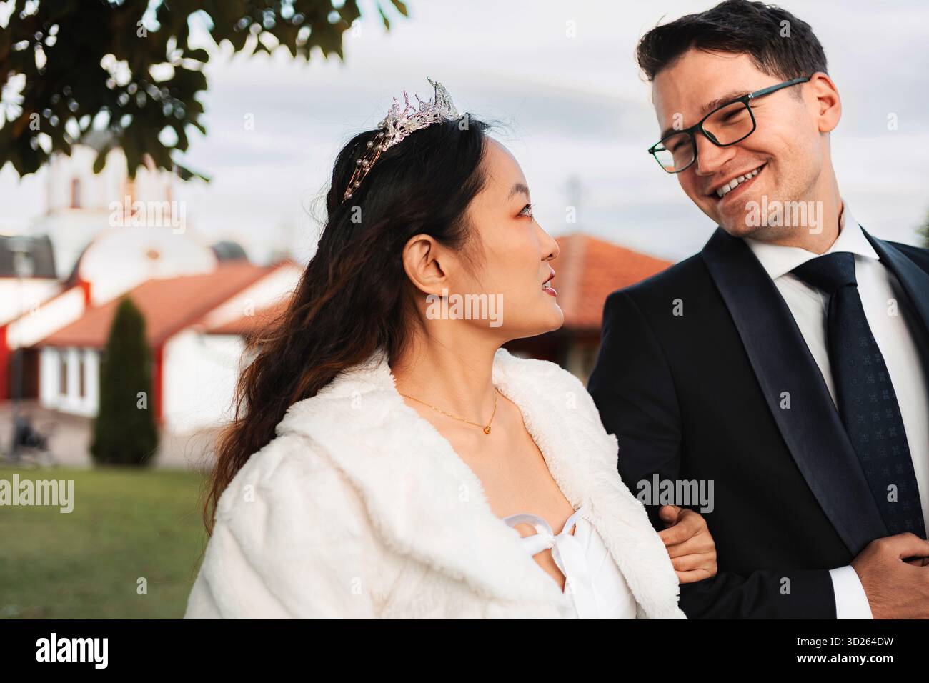 Intercultural wedding couple sharing a loving moment outside church ...