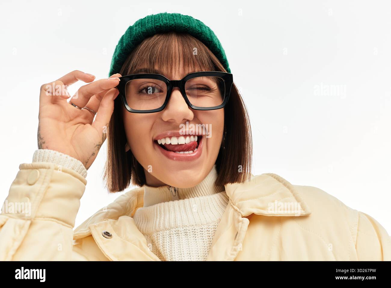 Joyful young woman showcases her playful style and confidence while ...