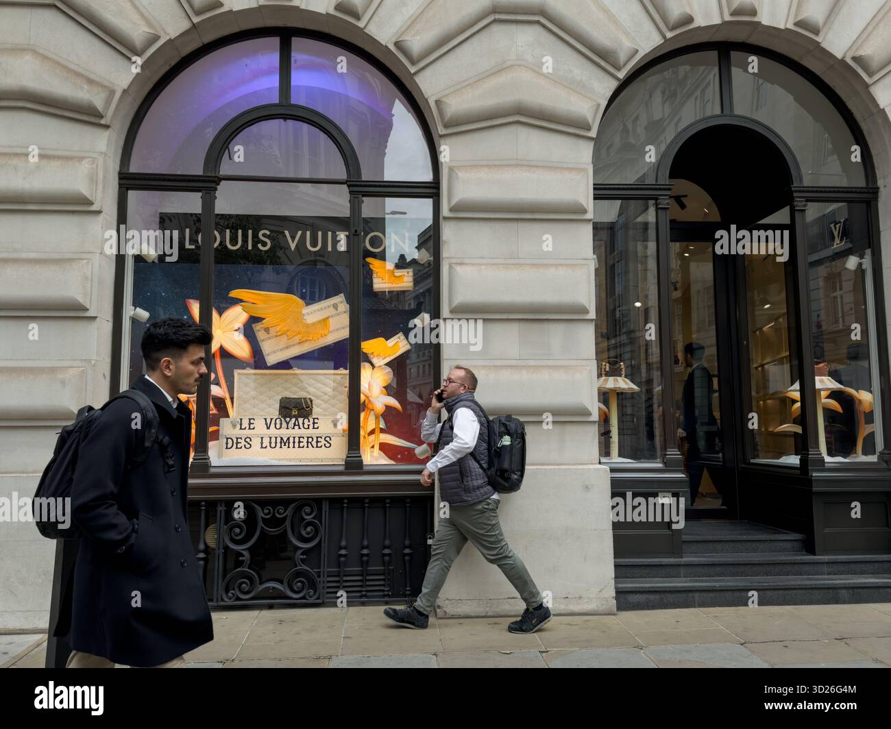 People walk by the elegant Louis Vuitton boutique in the heart of ...