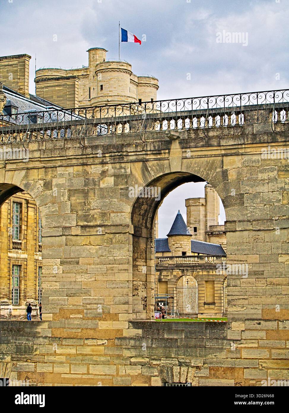 A historic stone structure features large arches, with a glimpse of a ...