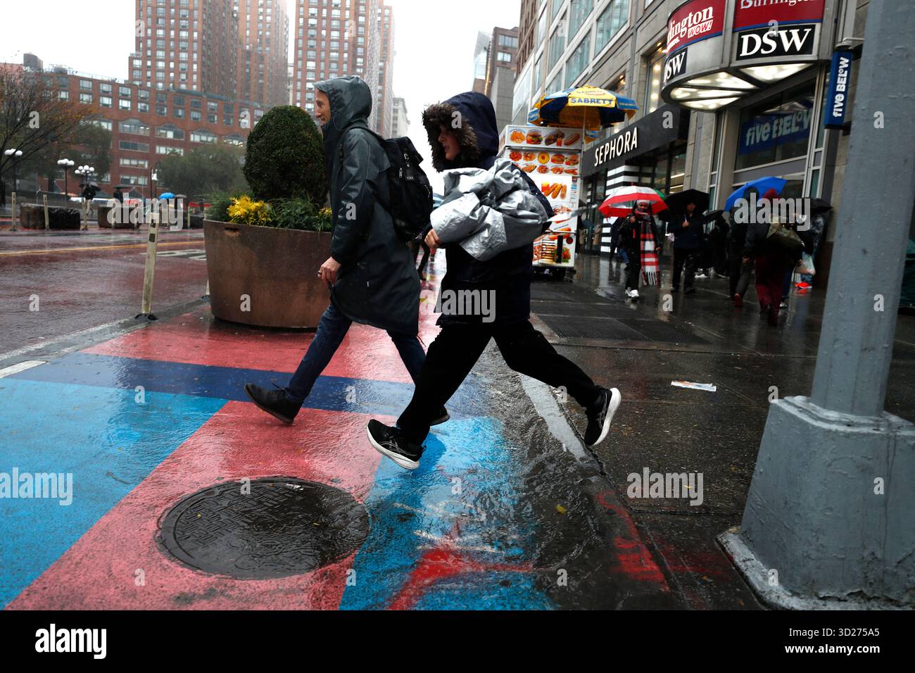 New York City, USA. 30th Oct, 2025. People negotiatie large puddles of ...