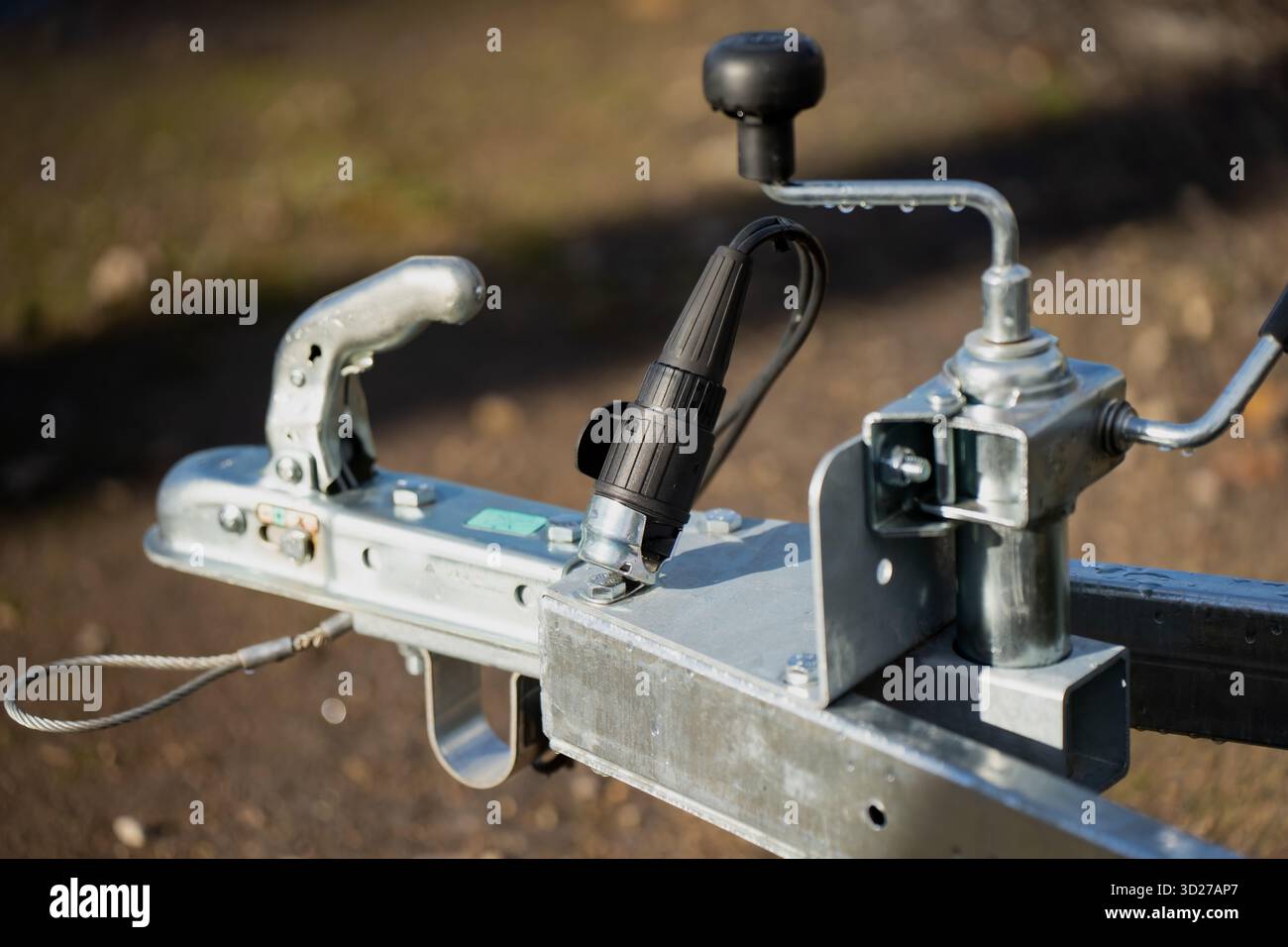 Metal trailer hitch with hand crank and electrical plug representing ...